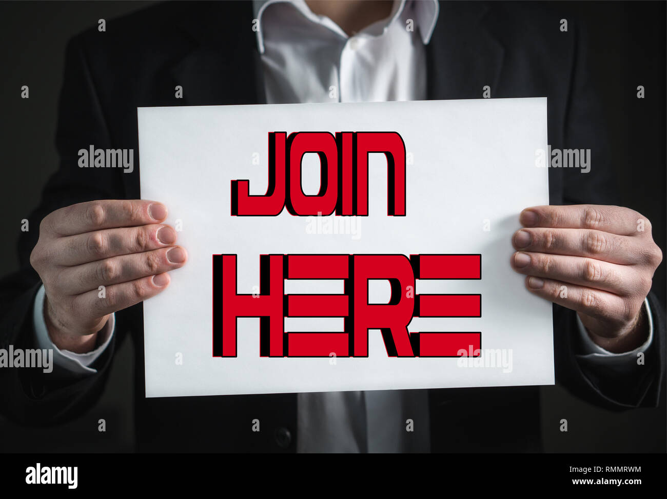Man hands holding white cardboard or placard against black background ...