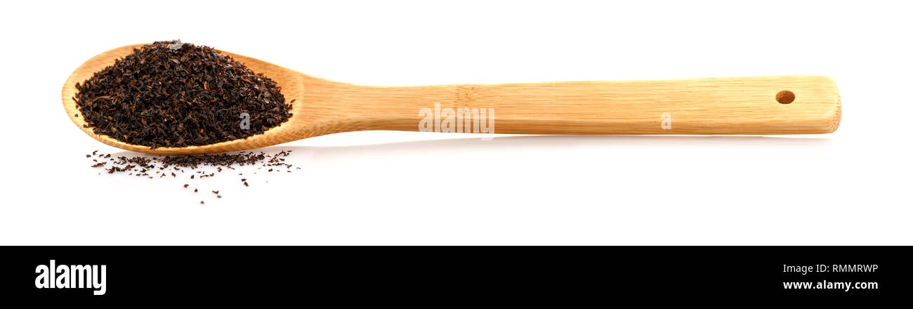 Black tea in a wooden spoon. Large leaf tea. Isolated on white ...