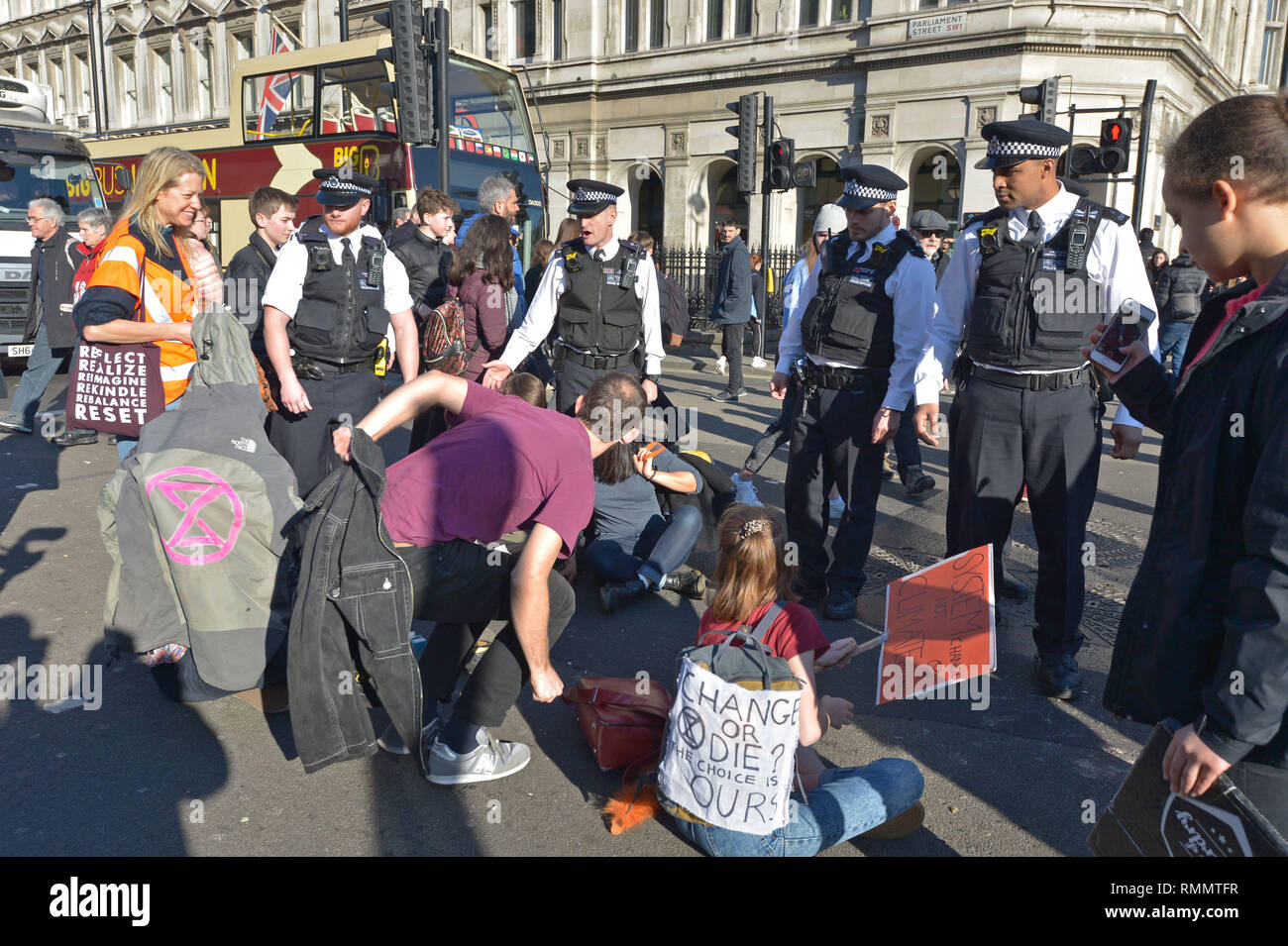 Police try to move demonstrators sitting in the road during a climate ...