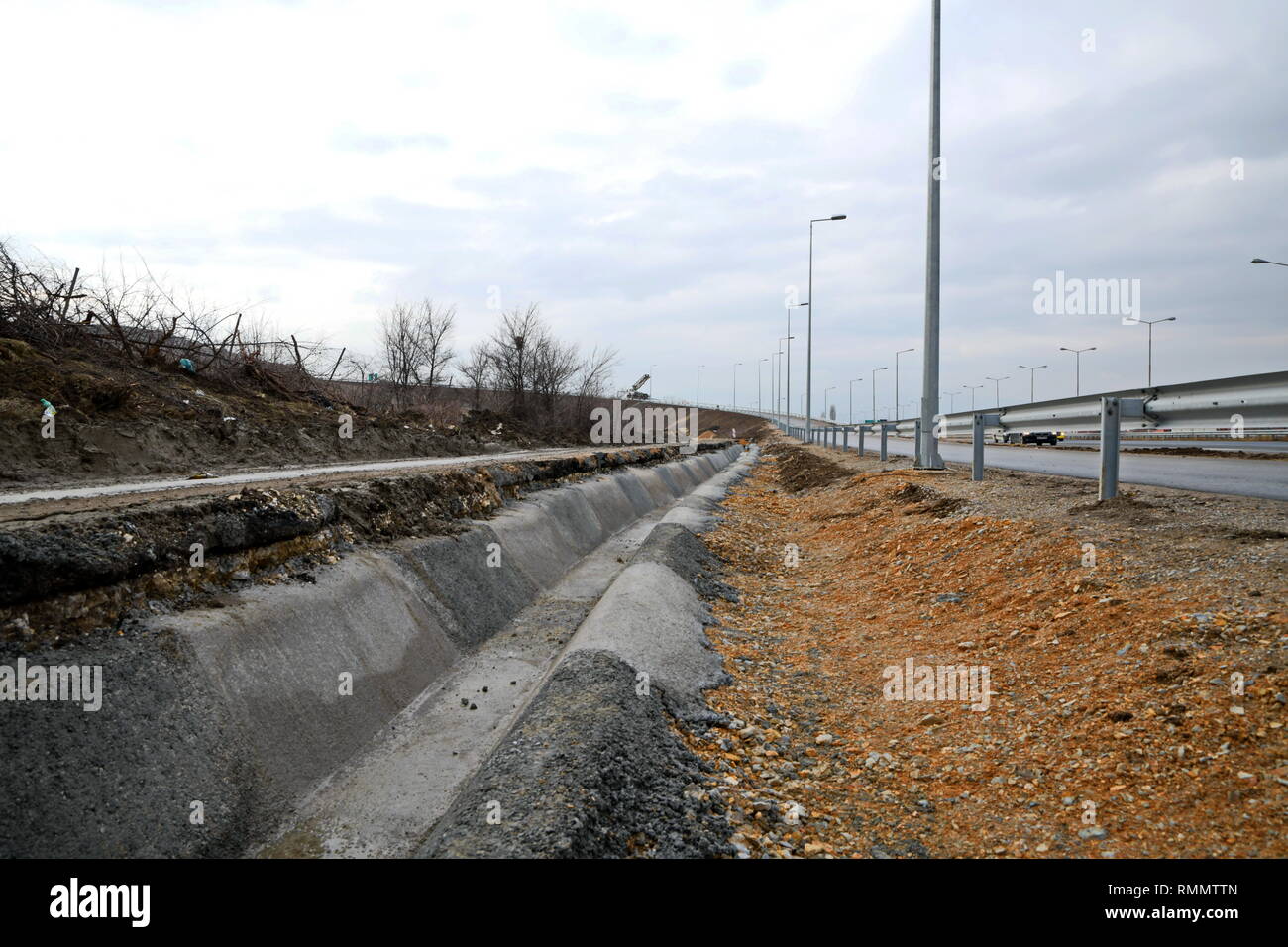 Canal for draining water along the highway Stock Photo - Alamy