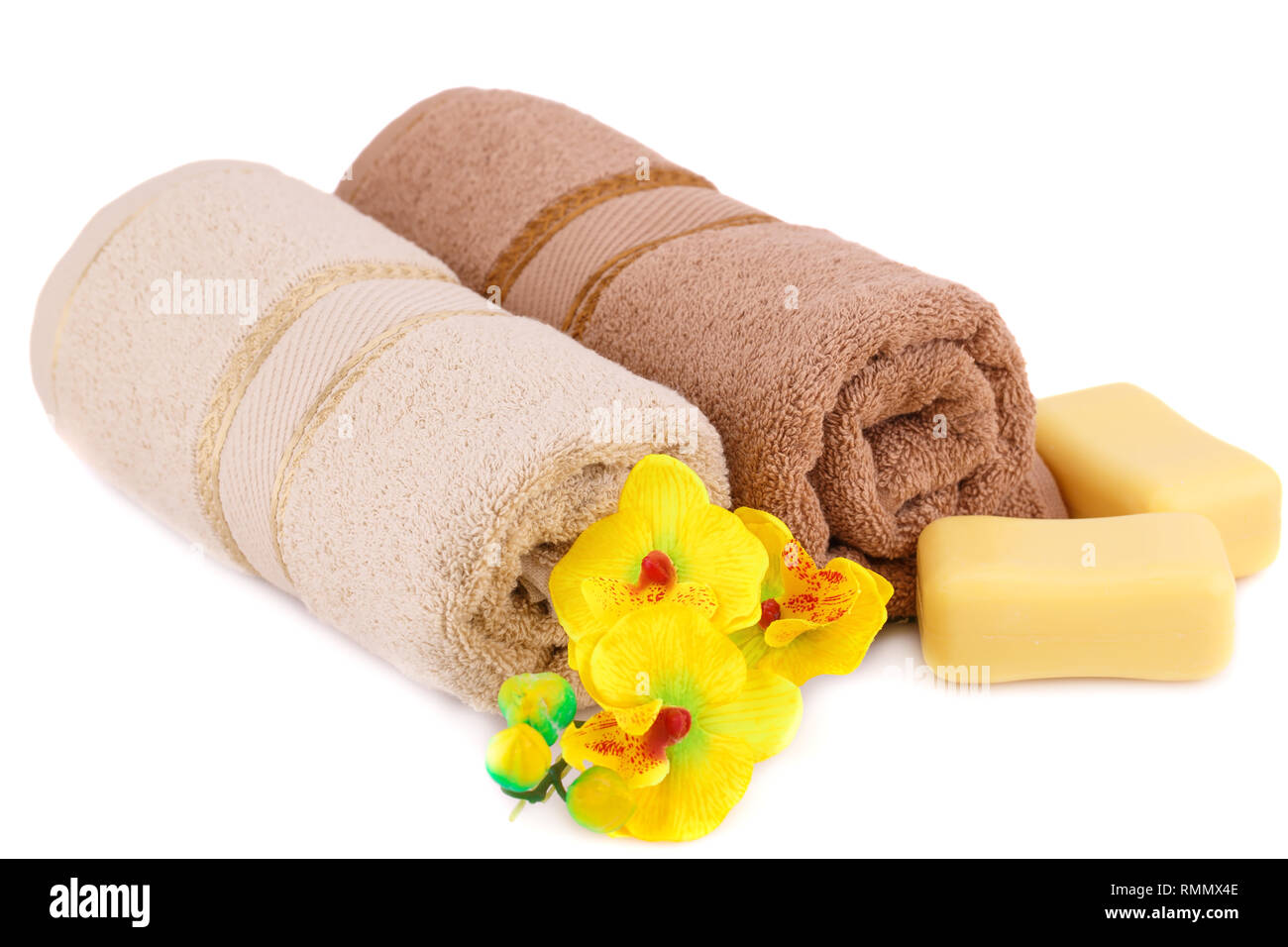 Rolled towels, soaps and flowers isolated on white background Stock ...