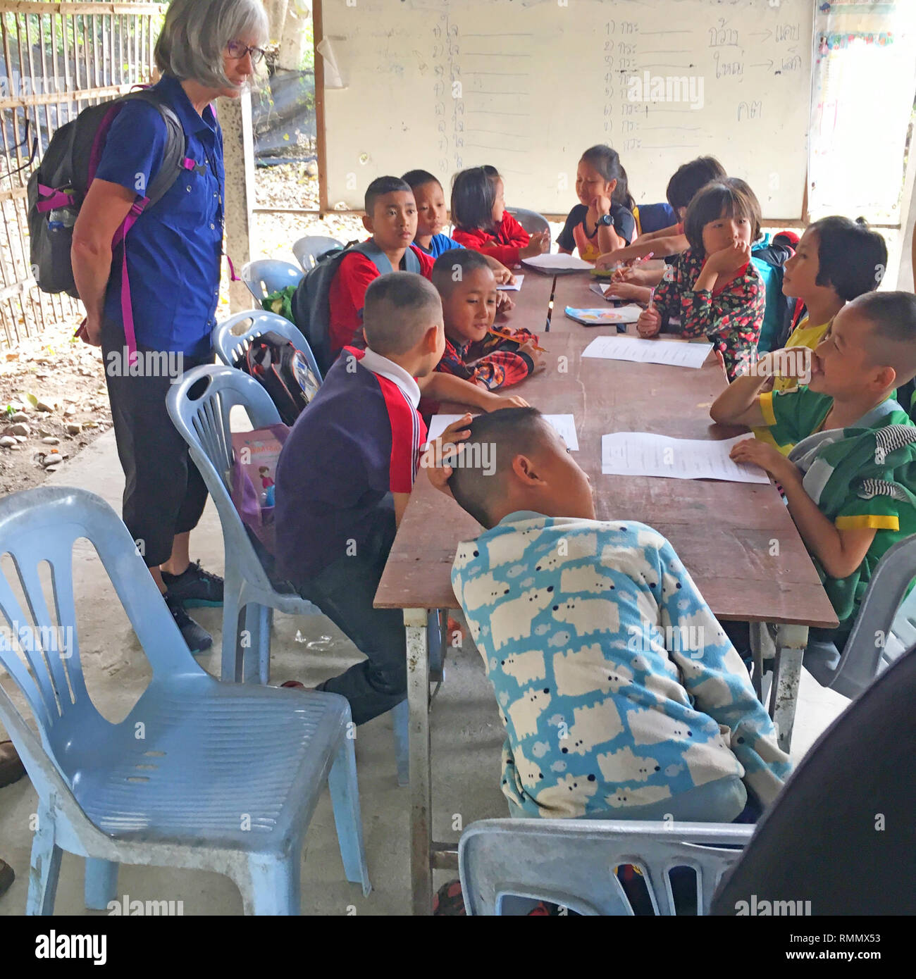 Caucasian woman observing children in a Thai classroom Stock Photo - Alamy