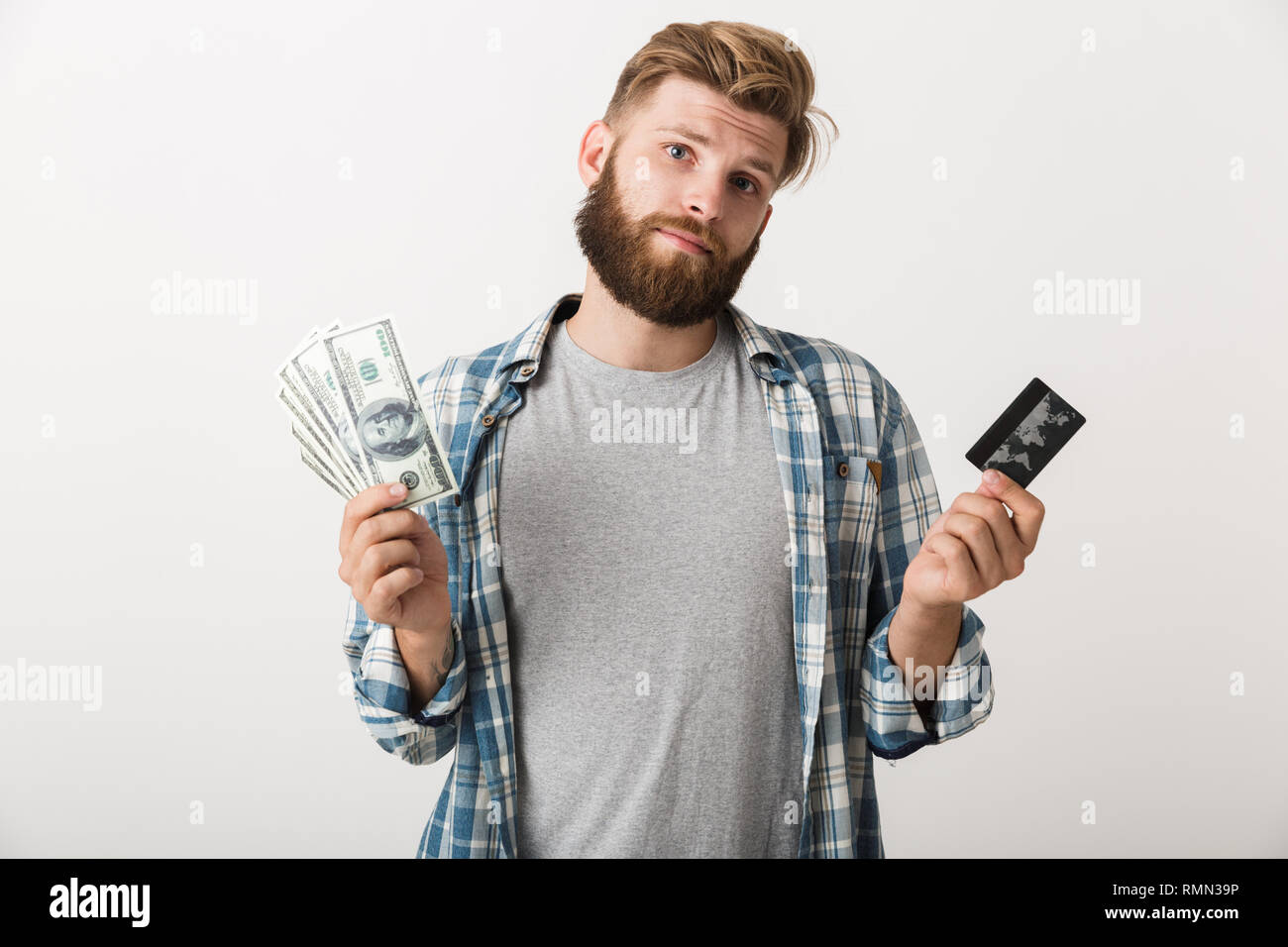 Portrait of a satisfied young bearded man showing money banknotes and ...
