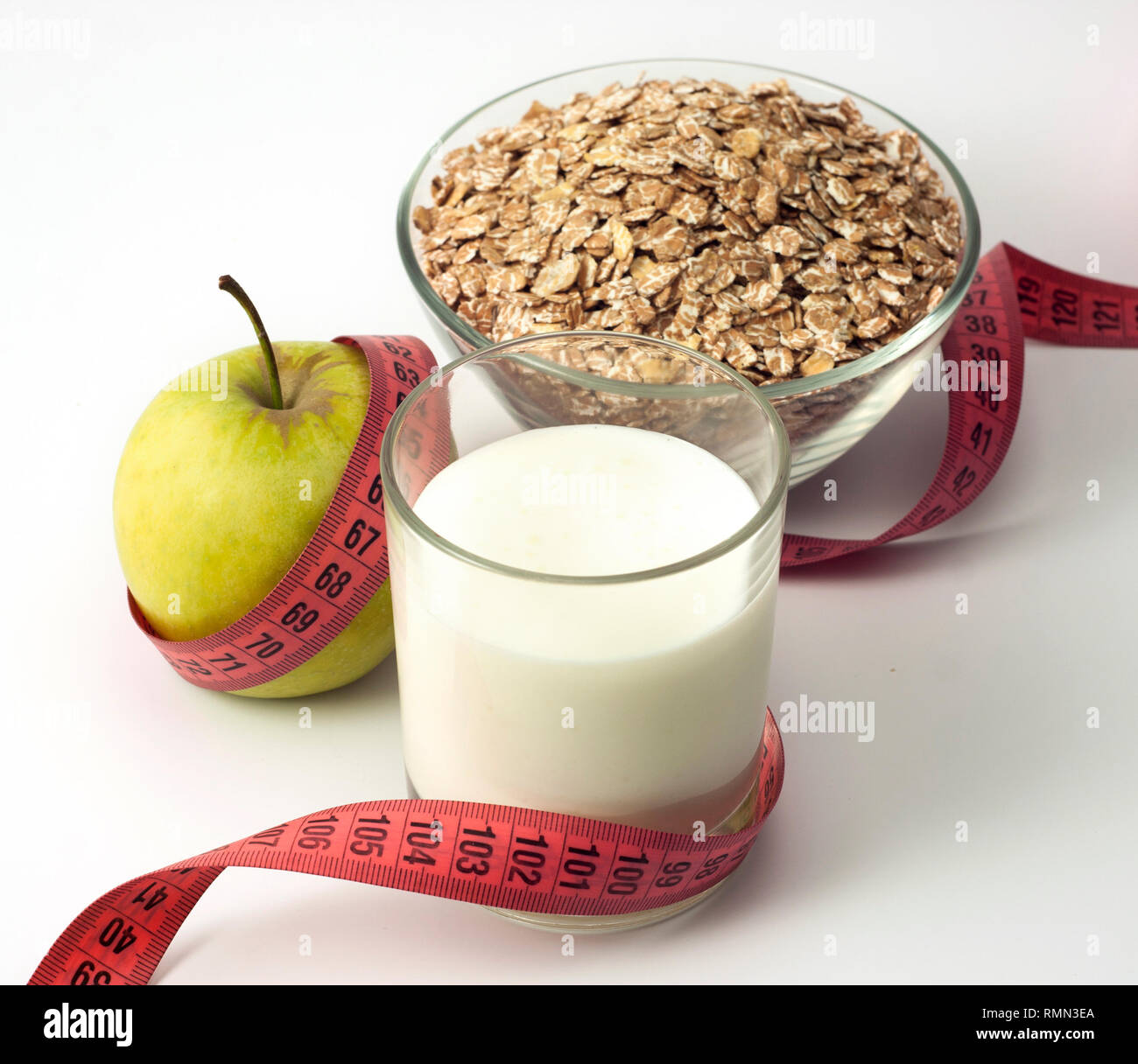 Green Apple, Kefir and Oatmeal with Measuring tape on white background ...