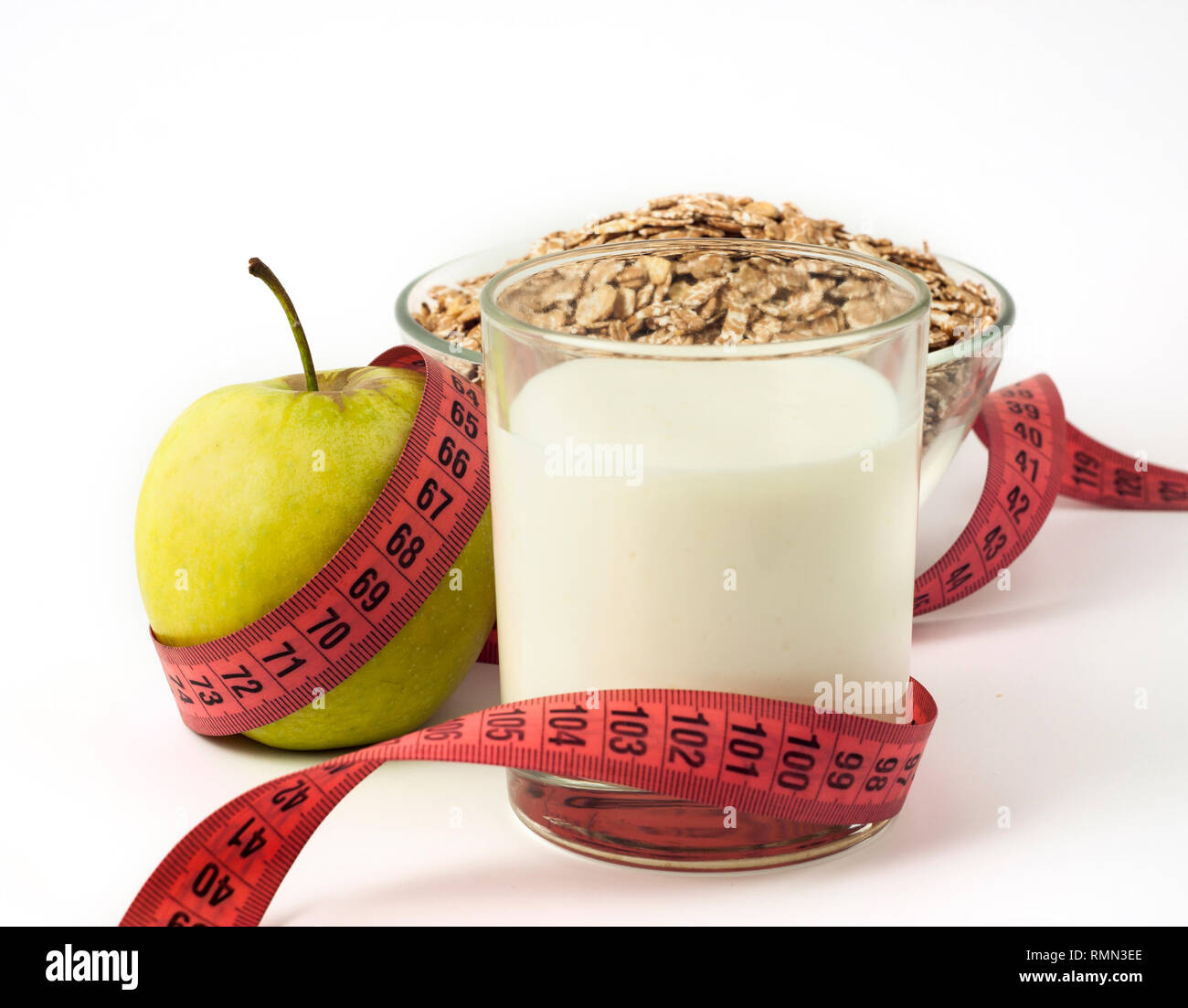 Green Apple, Kefir and Oatmeal with Measuring tape on white background ...
