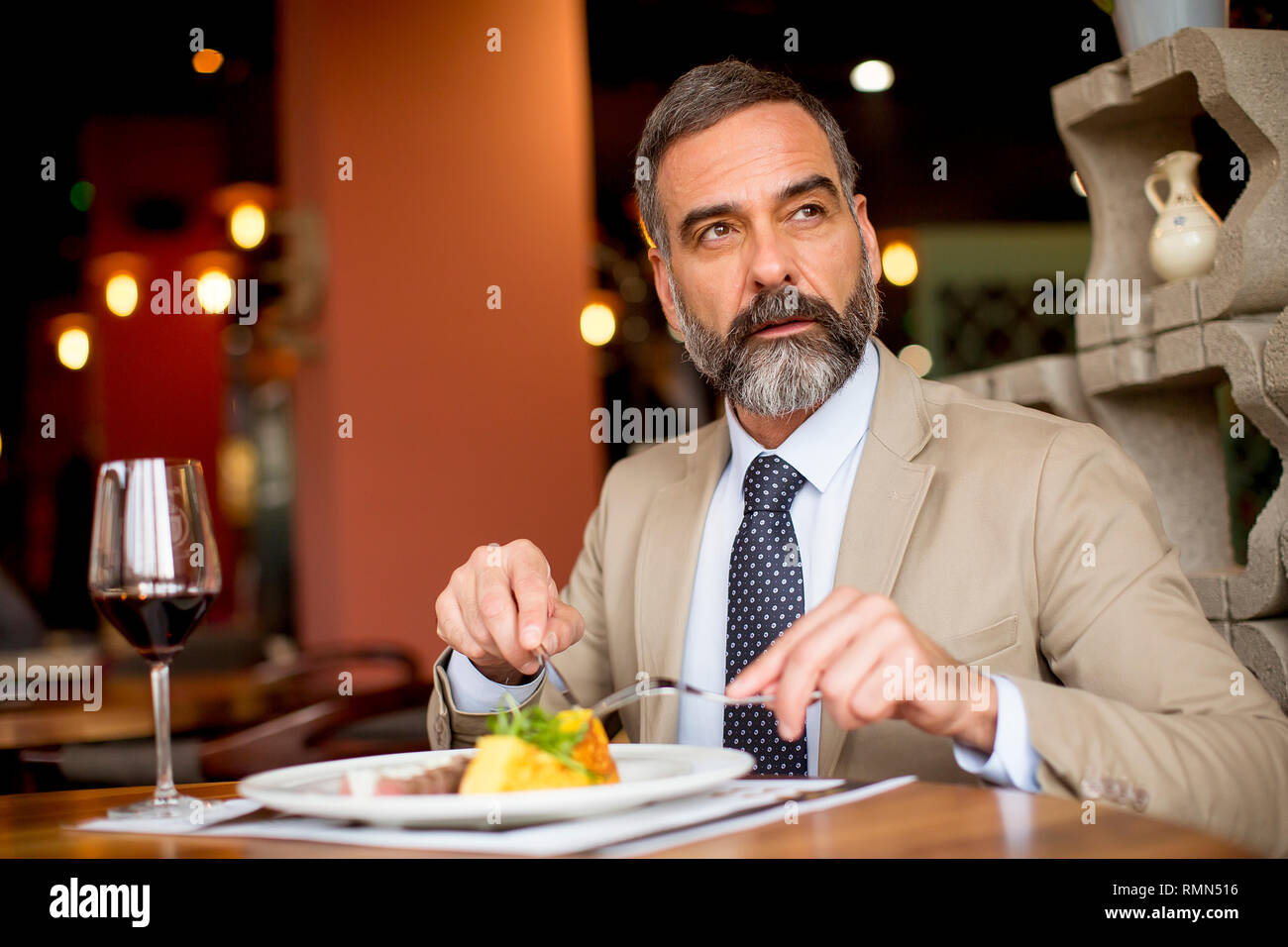 Portrait of handsome senior man eating lunch in restaurant Stock Photo ...