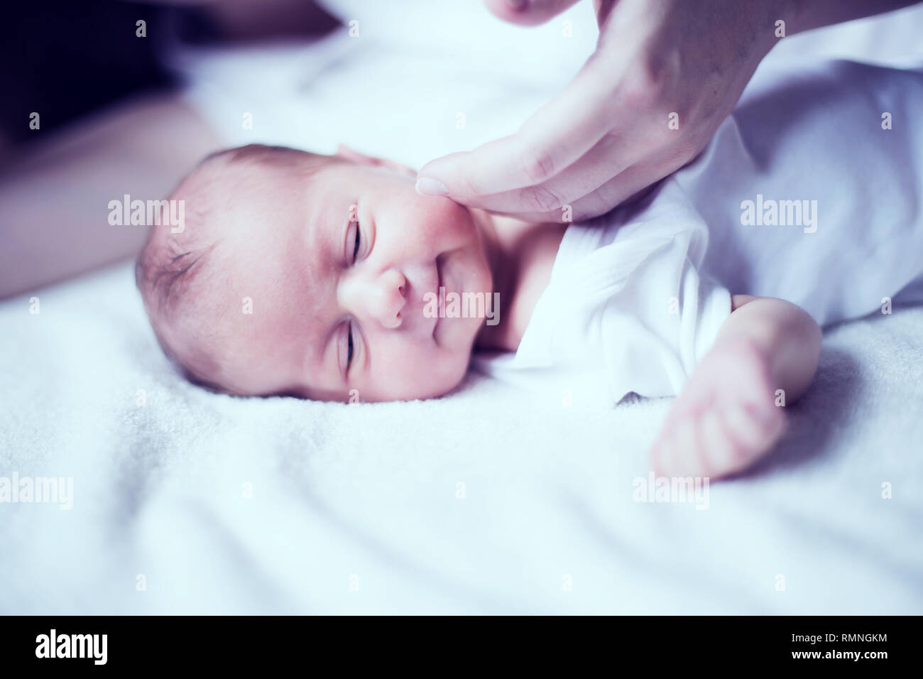 mother caressing a newborn baby lying on the bed Stock Photo - Alamy