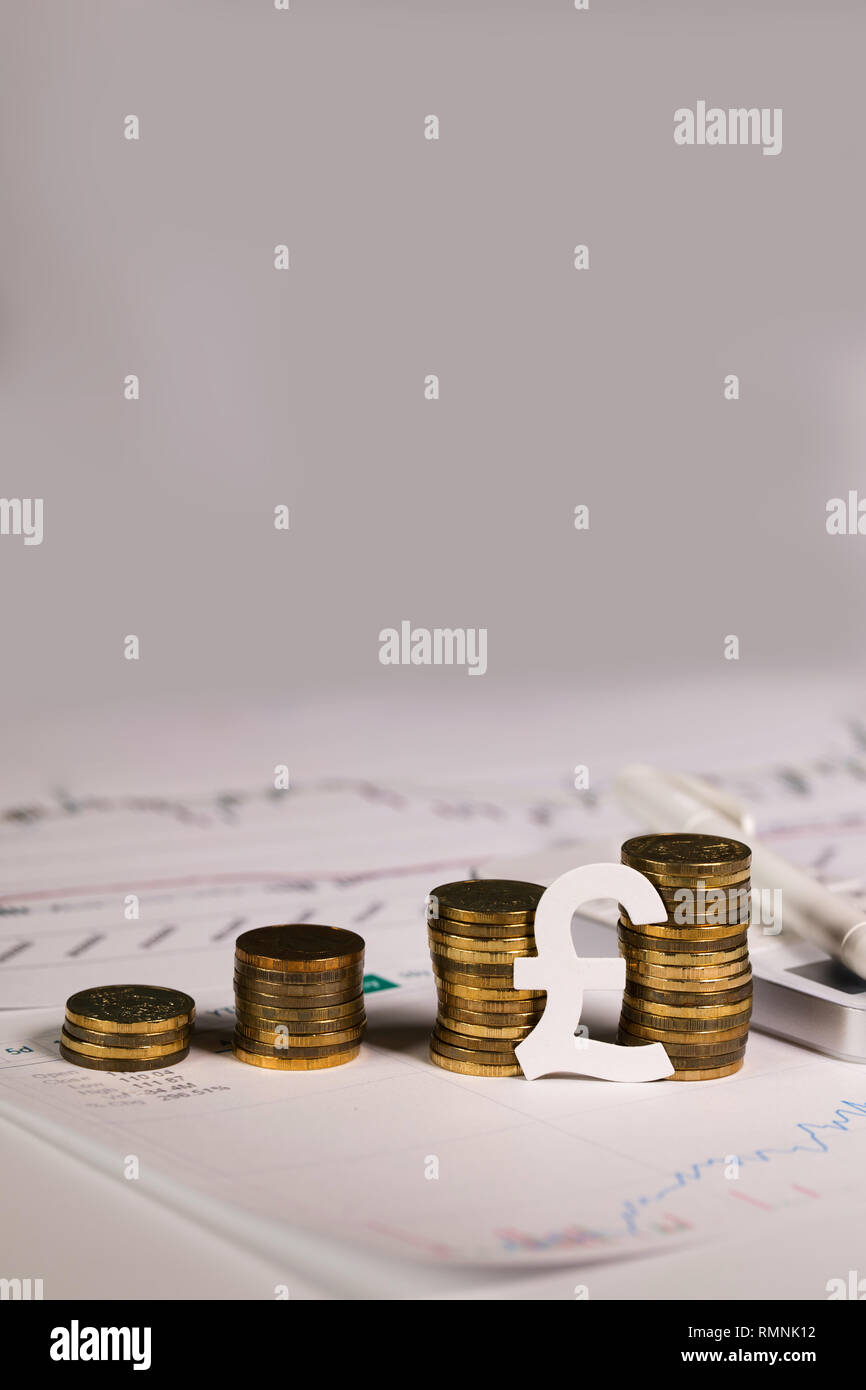 Paper sign of British pound at stacks of coins. Closeup Stock Photo - Alamy