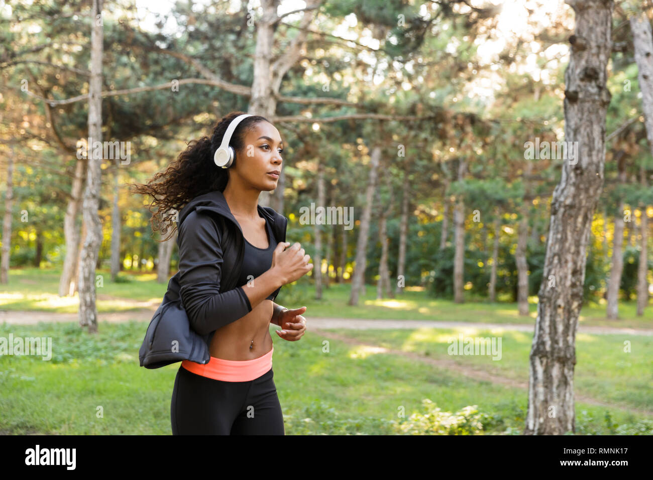 Image of brunette woman 20s wearing black tracksuit working out while ...