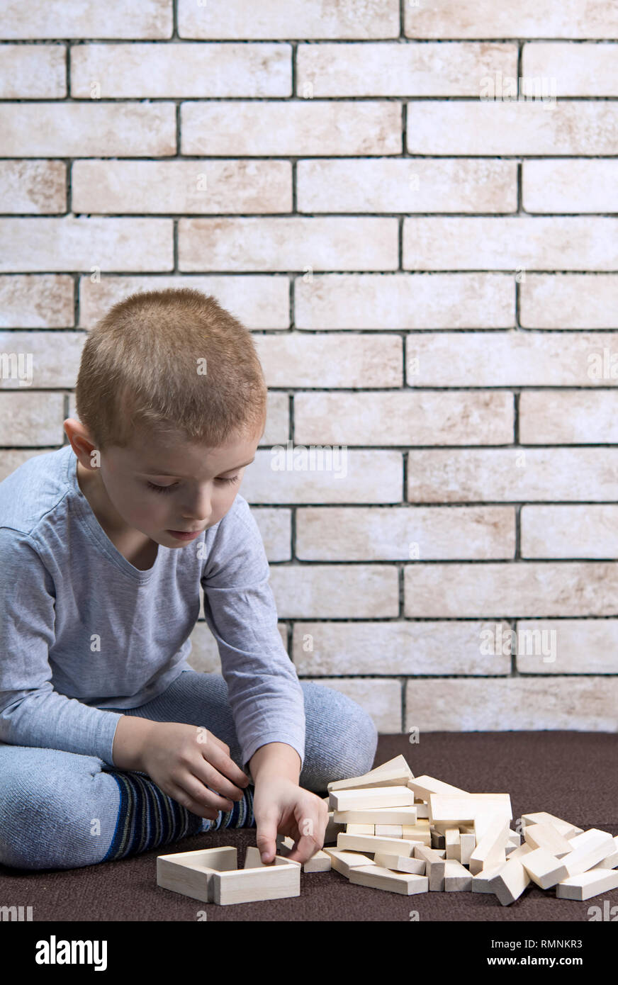 little boy playing together with wooden blocks Stock Photo - Alamy