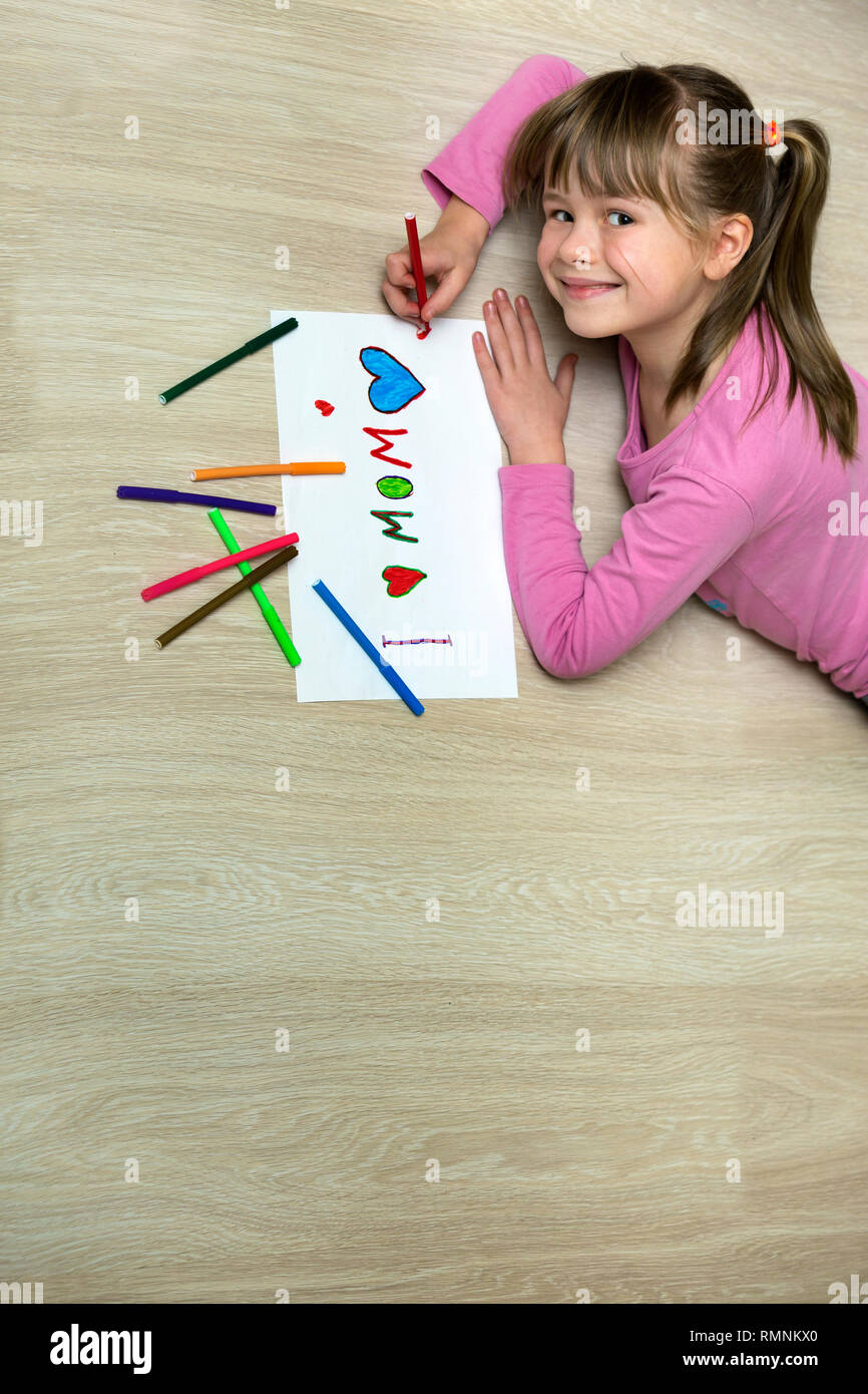 View from above of cute child girl drawing with colorful crayons I love ...