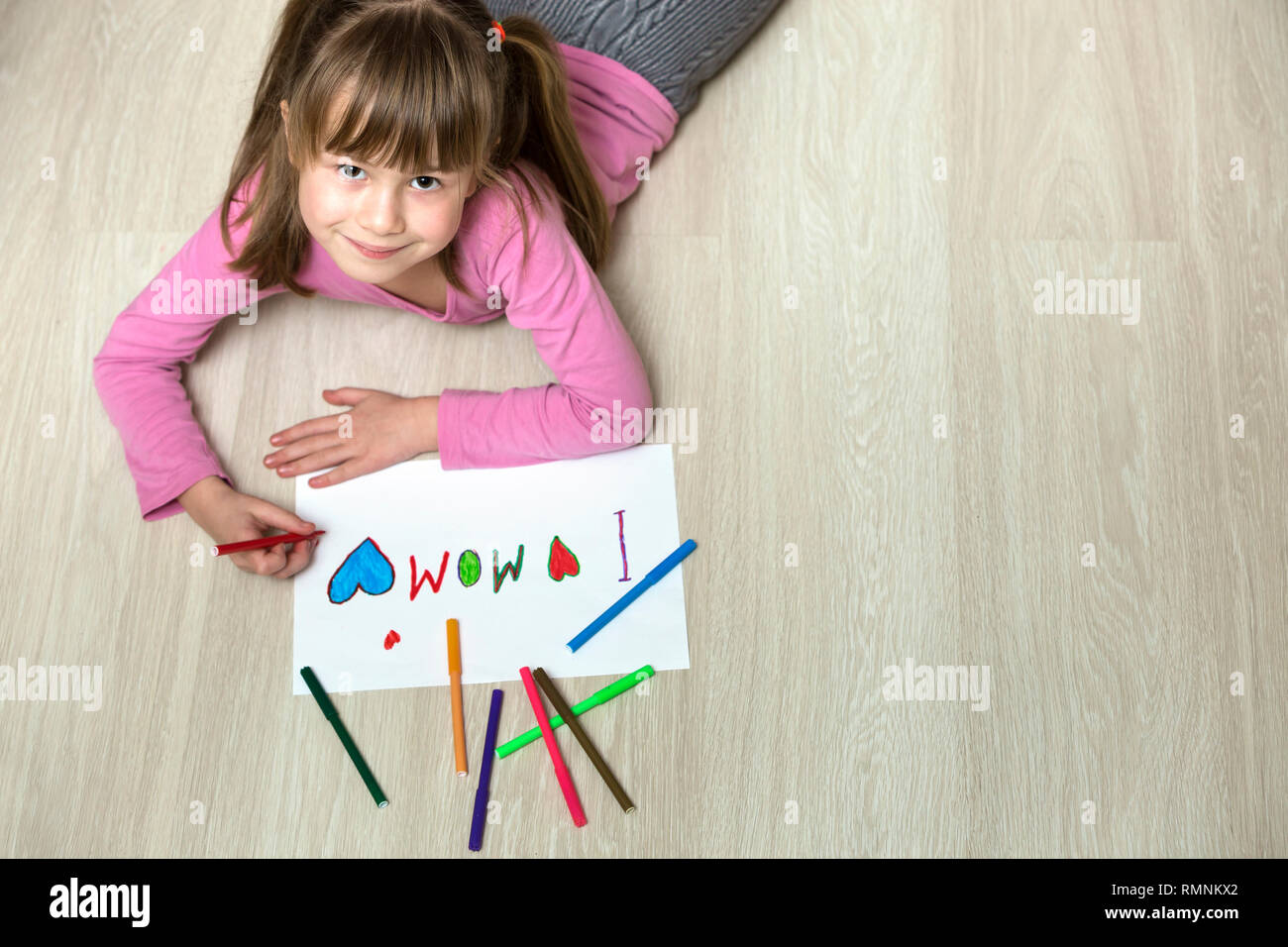 View from above of cute child girl drawing with colorful crayons I love ...