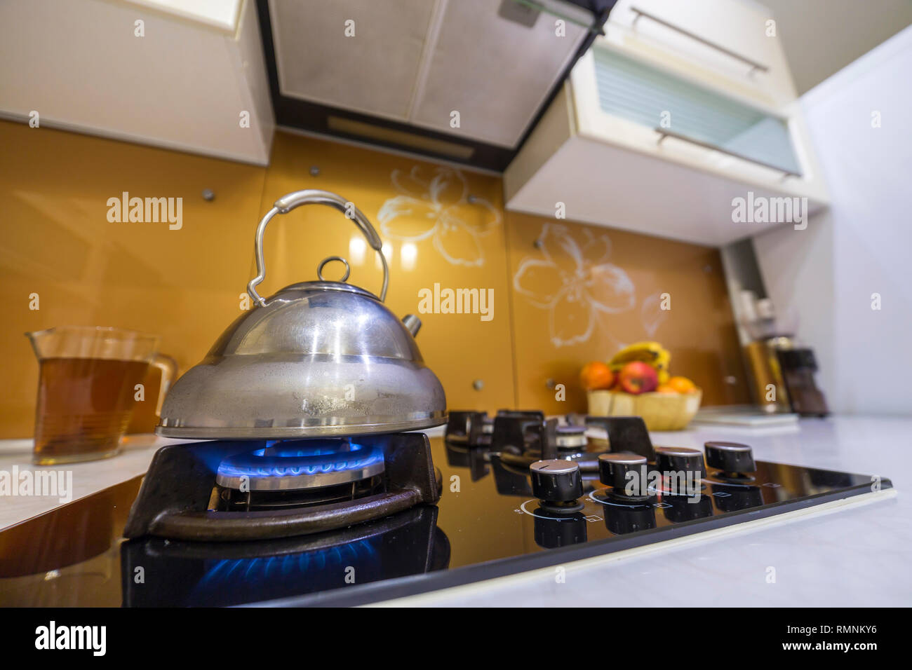 Shiny stainless tea kettle teapot with boiling water on burning gas ...
