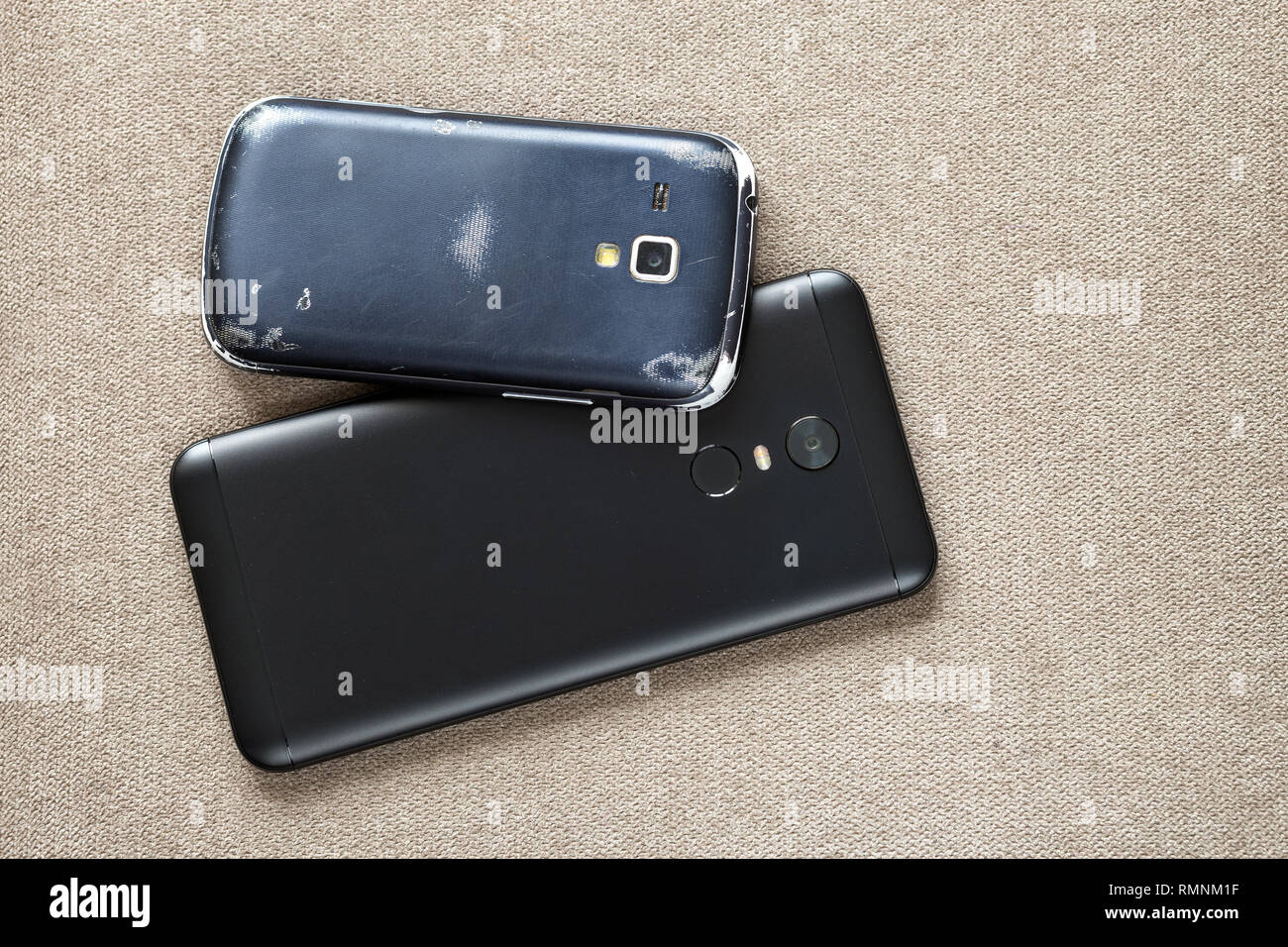 Comparison of two black mobile phones, old cellphone and new modern on ...