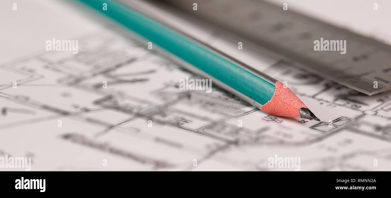 Coal pencil and metal ruler on a technical drawing of an apartment ...