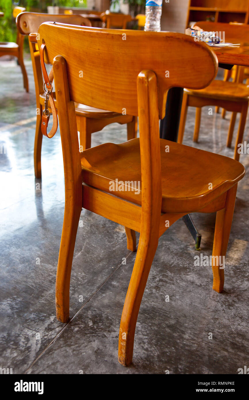 Wooden chair in arestaurant with a locker for the bags Stock Photo - Alamy