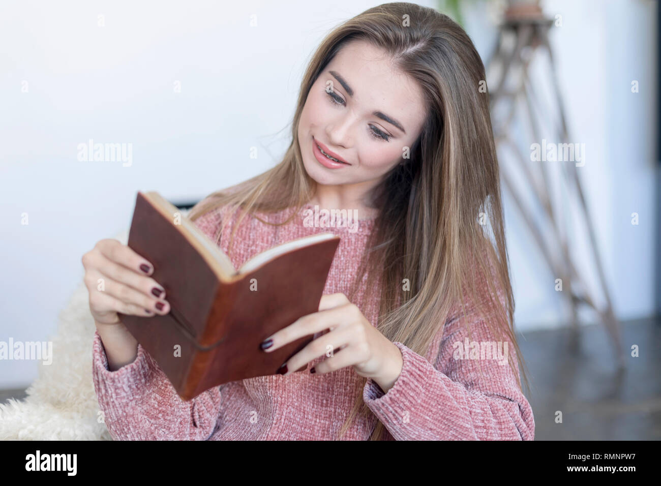 Teen reading a paper book sitting on a couch Stock Photo - Alamy