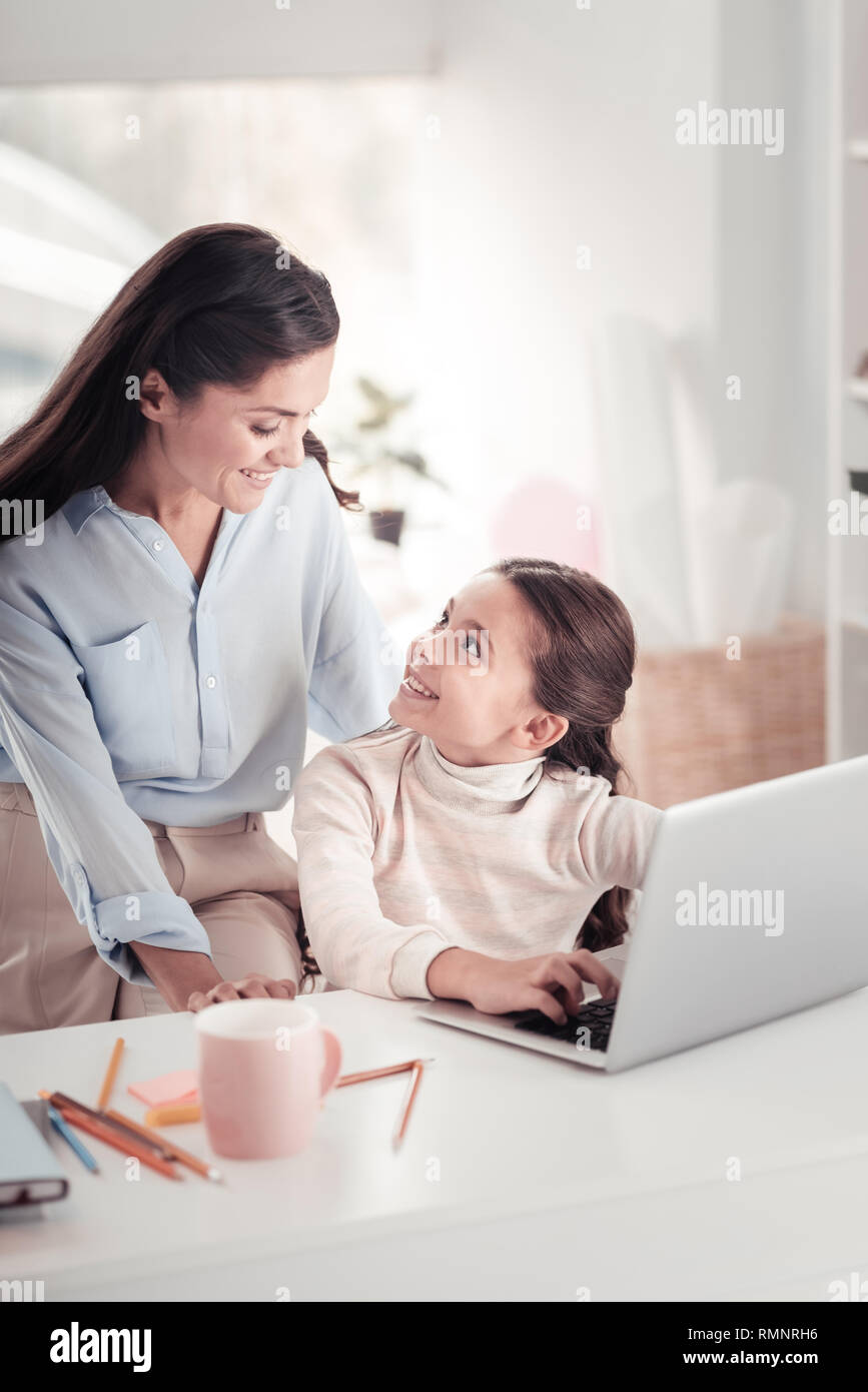Mothers care. Caring smiling mother keeping her eye on daughter while ...