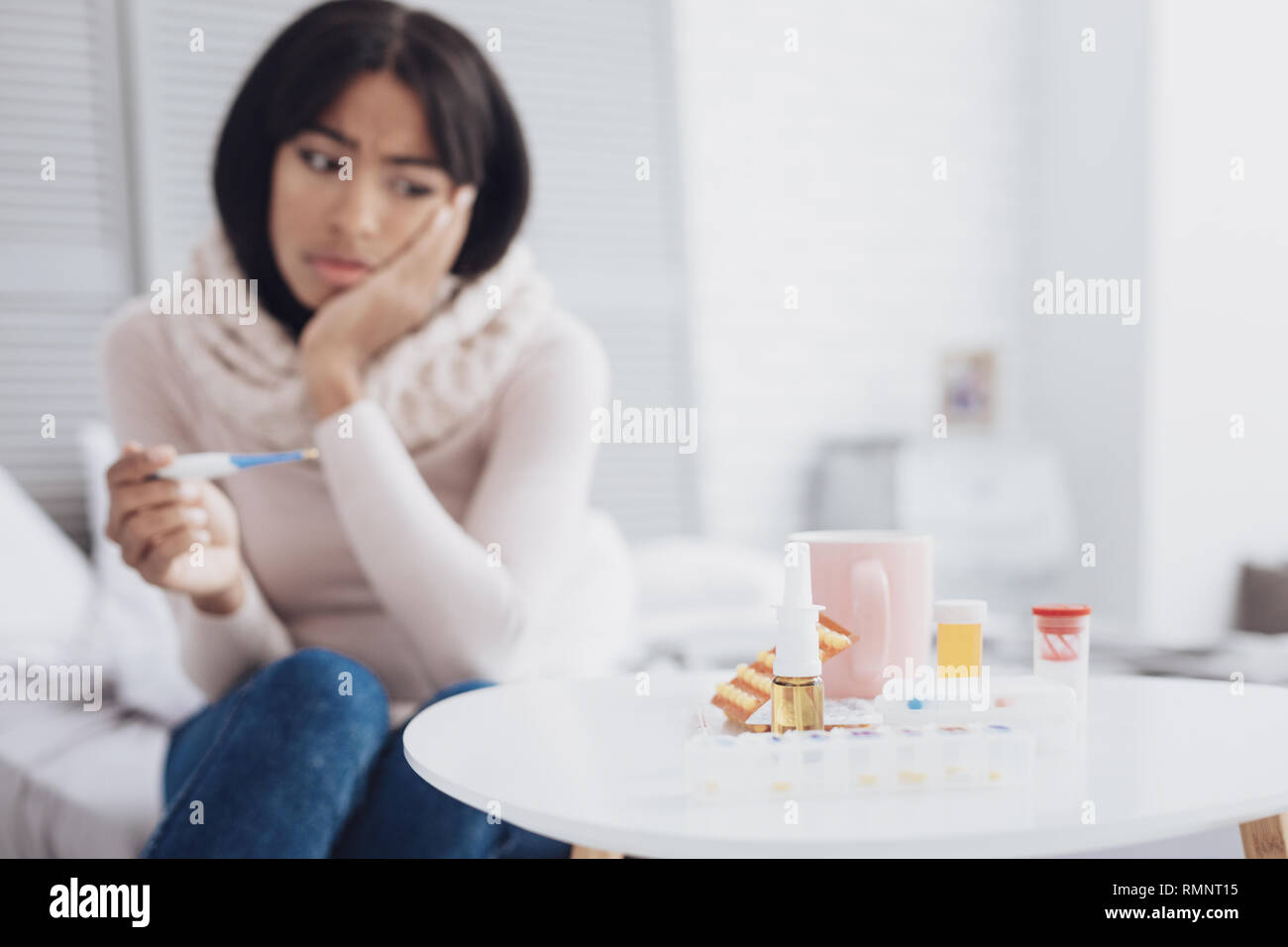 Low spirits. Negative delighted female person touching her cheek while ...