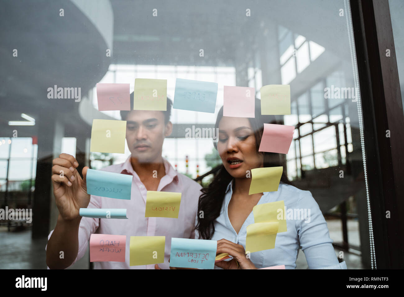 asian male and female business partner brainstorming by sticking idea ...