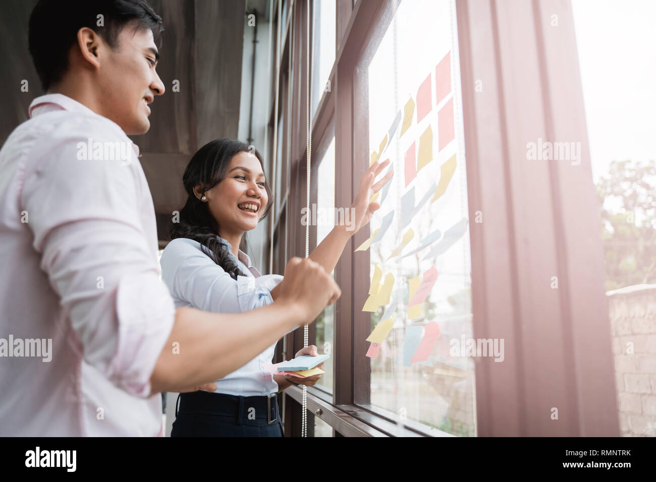 asian male and female business partner brainstorming by sticking idea ...