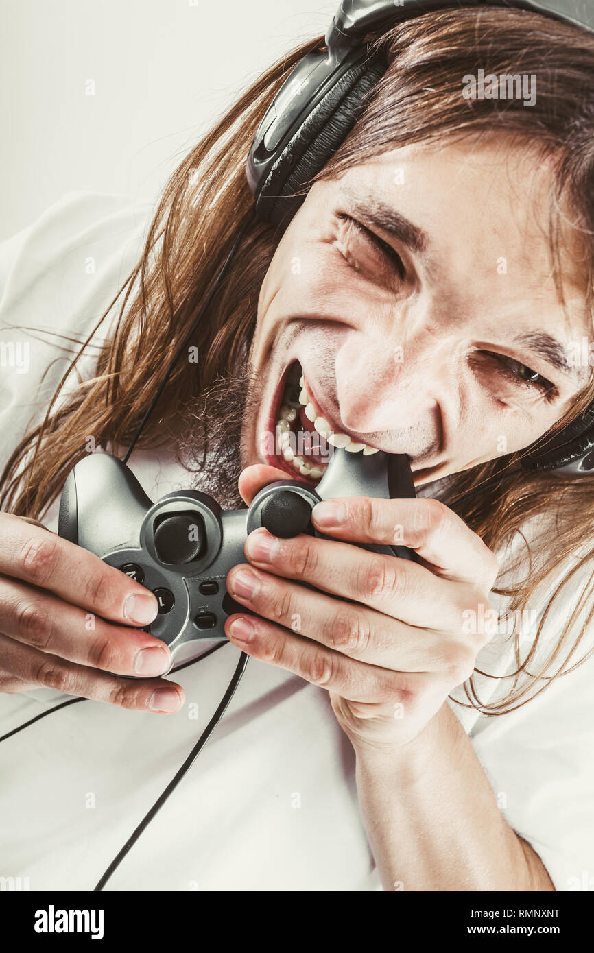 Addiction. Stressed depressed young man playing gaming on pad. Angry ...