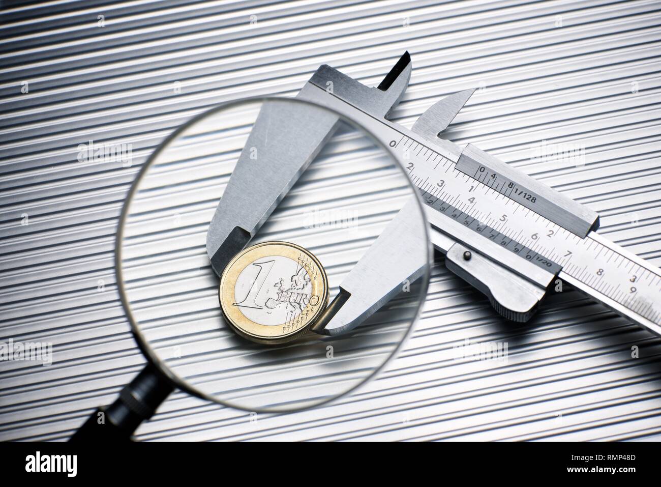 metal gauge measuring a one euro coin on a metal surface Stock Photo ...