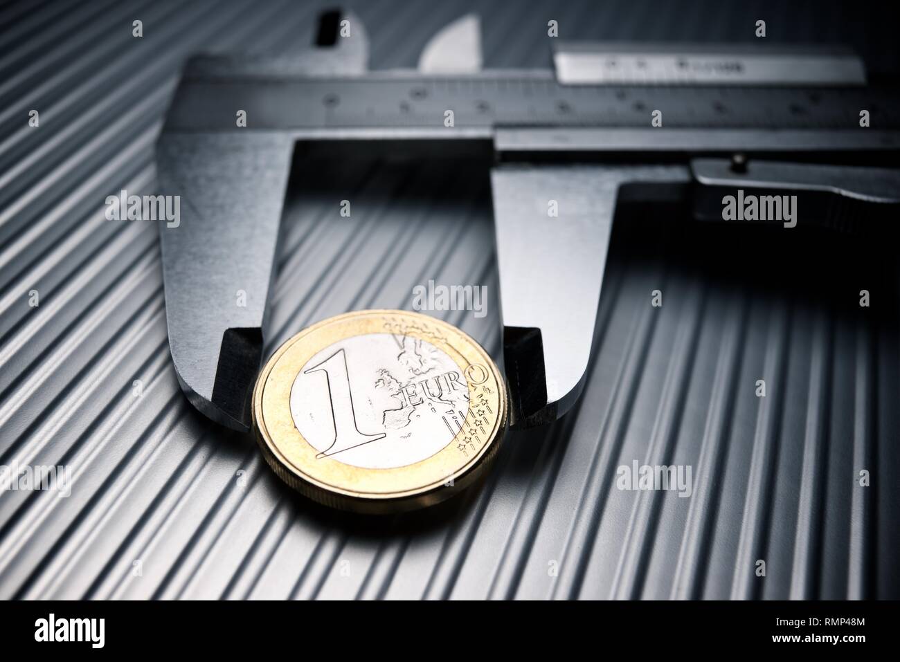 metal gauge measuring a one euro coin on a metal surface Stock Photo ...