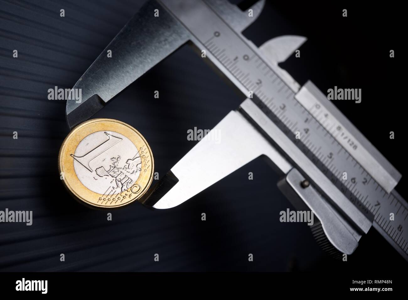 metal gauge measuring a one euro coin on a metal surface Stock Photo ...