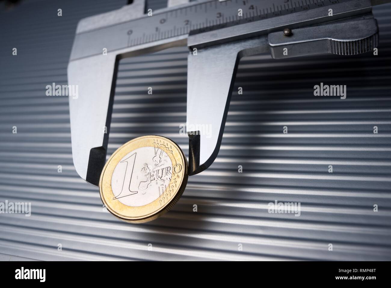 metal gauge measuring a one euro coin on a metal surface Stock Photo ...
