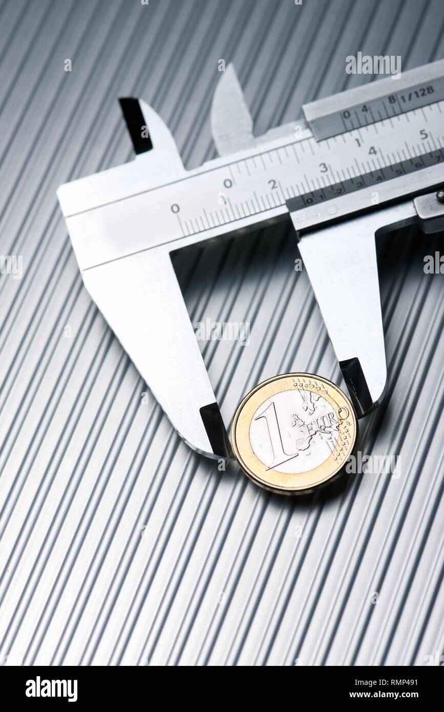 metal gauge measuring a one euro coin on a metal surface Stock Photo ...