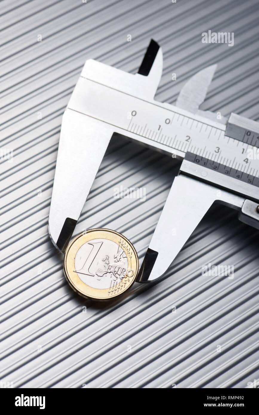 metal gauge measuring a one euro coin on a metal surface Stock Photo ...