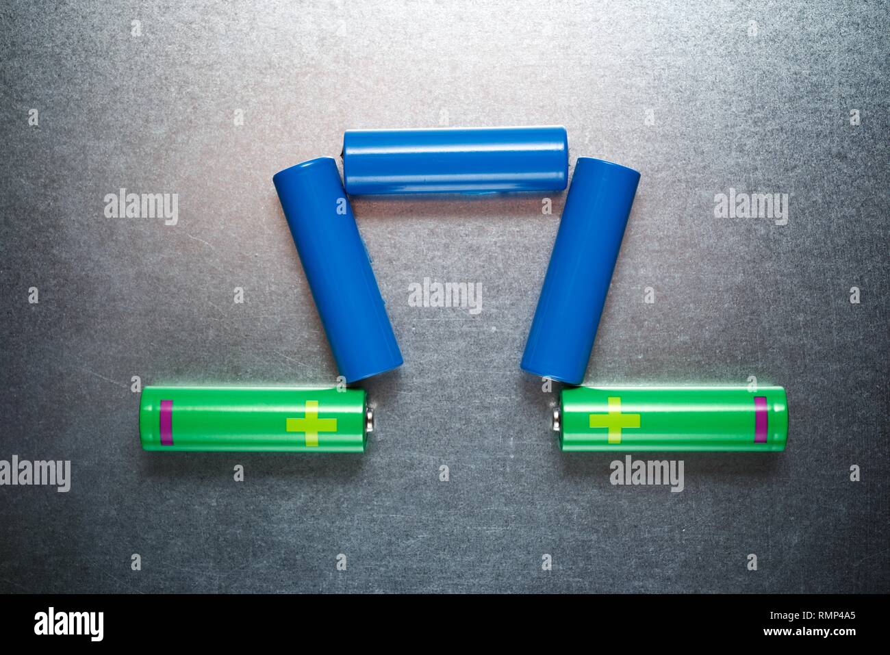 Batteries on a metal table forming the ohm sign Stock Photo - Alamy