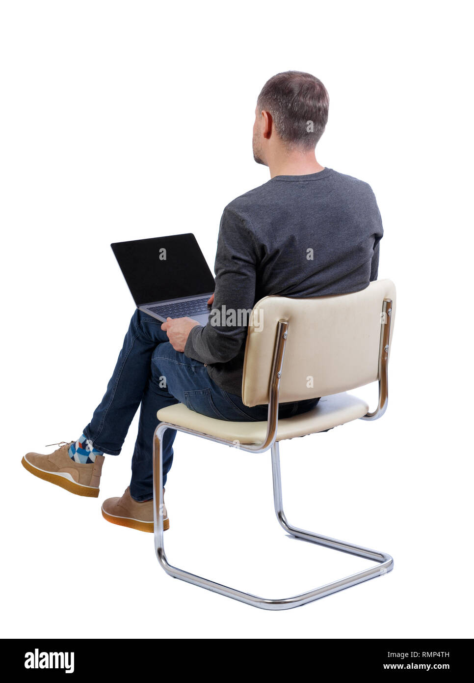 Back view of a man who sits on a chair with a laptop. Rear view people ...
