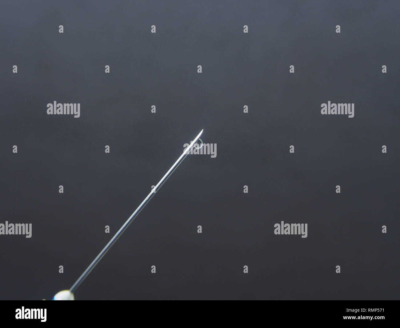 A drop of medicine on the end of a medical syringe needle. Photo on a ...