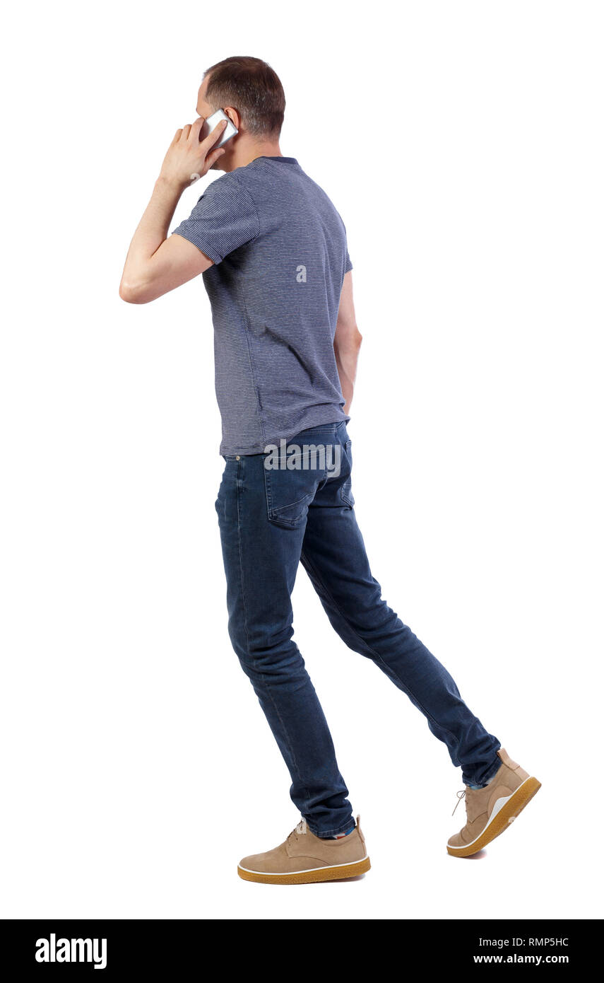 a side view of man walking with a mobile phone. backside view of person ...