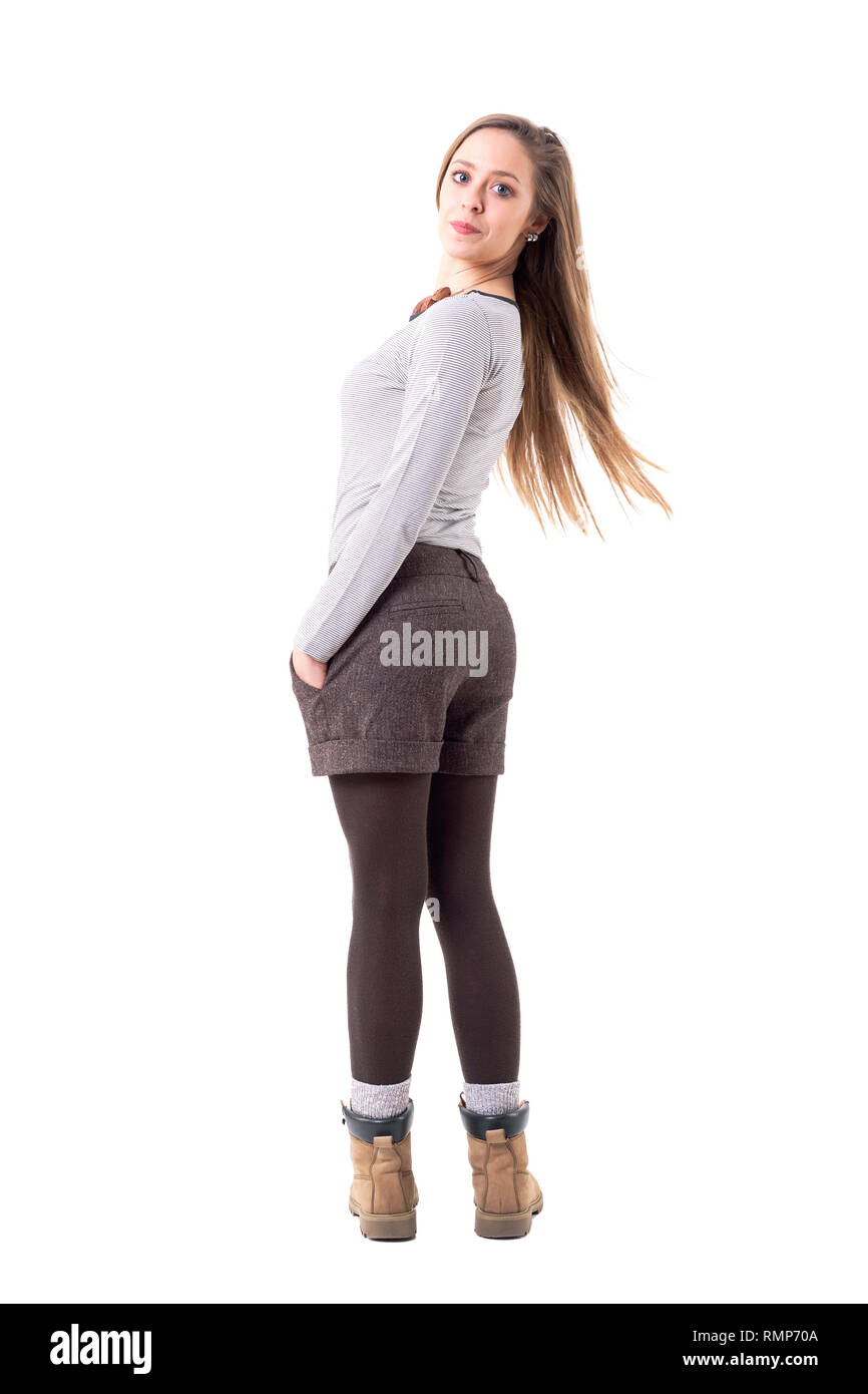 Rear view of charming playful cute young woman turning at camera ...