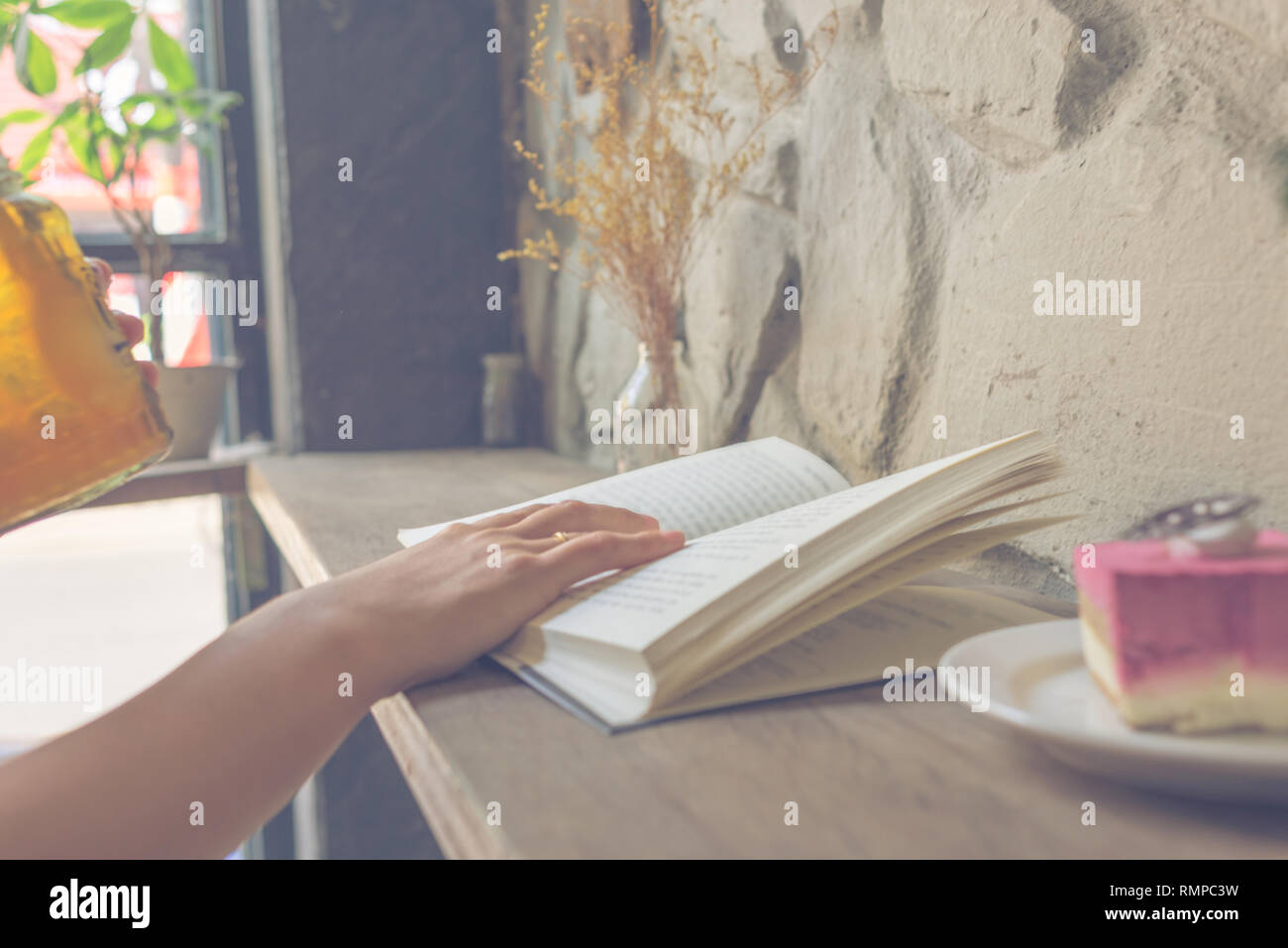 Side view of young girl reading book at cafe Stock Photo - Alamy