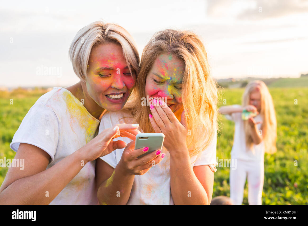 Indian festival of holi, people concept - Two laughing girls with ...