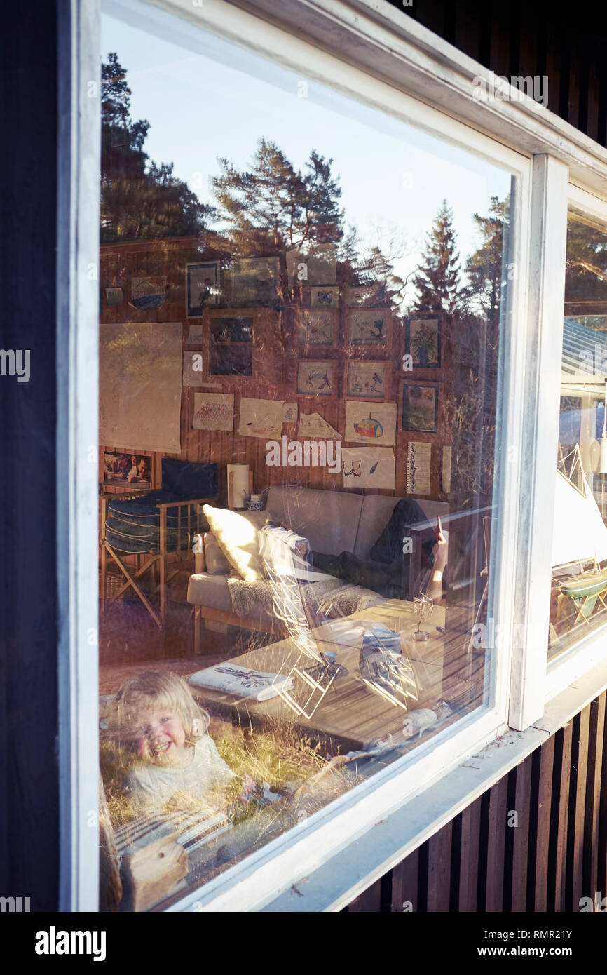 Girl looking through window Stock Photo - Alamy