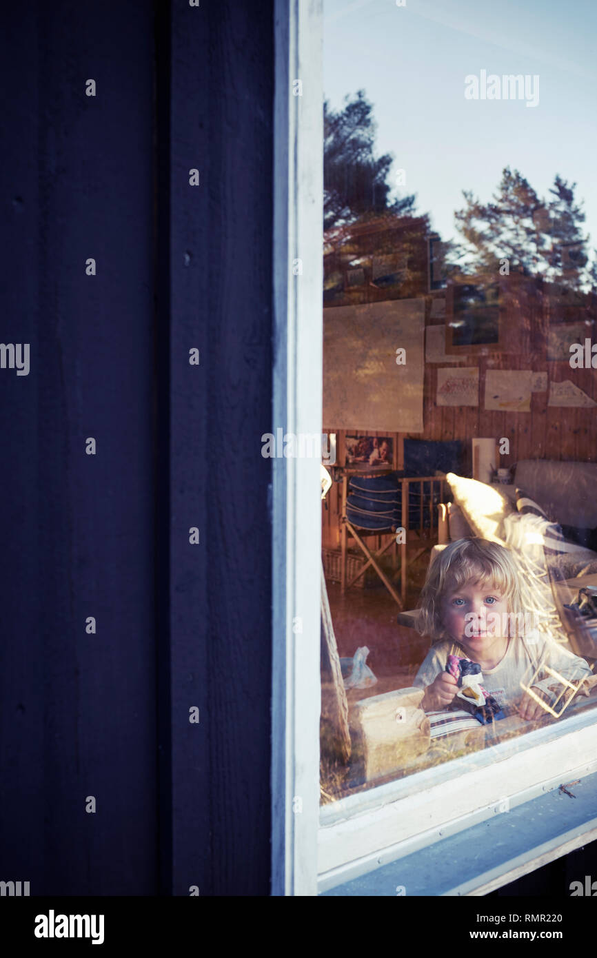 Girl looking through window Stock Photo - Alamy