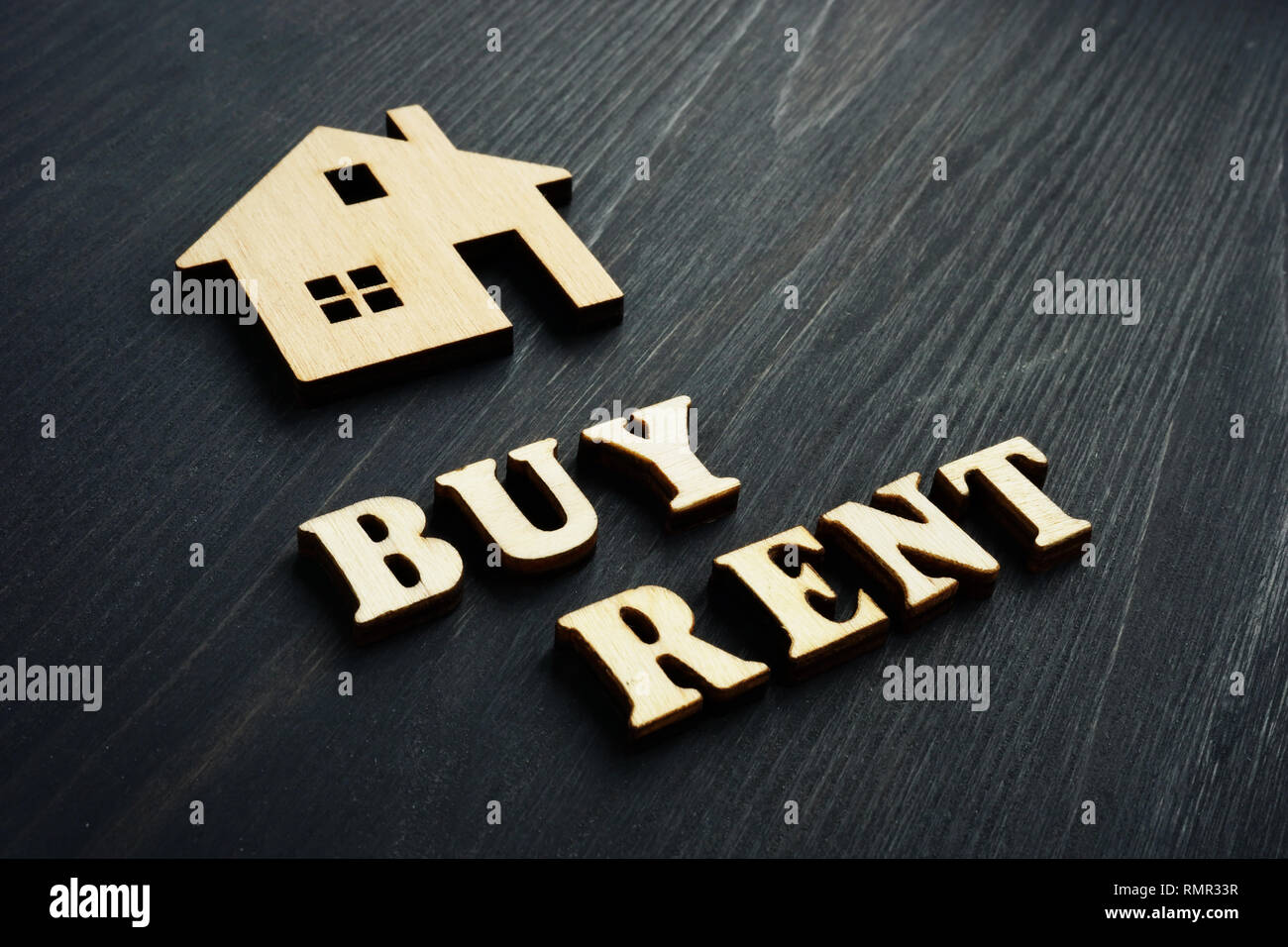 Buy or rent. Words with wooden model of home Stock Photo - Alamy