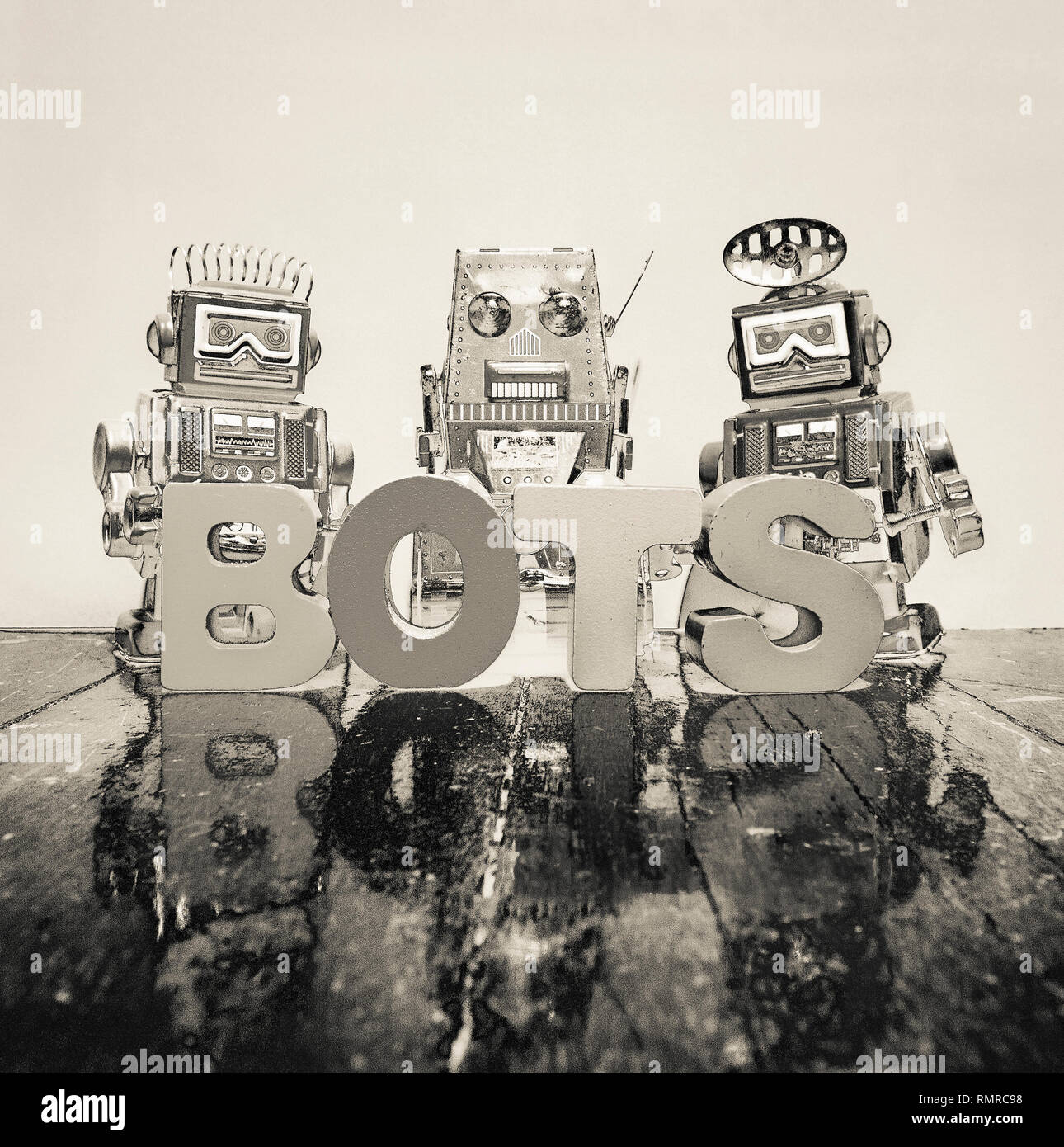 three retro robot toys and the word BOTS on a wooden floor Stock Photo ...