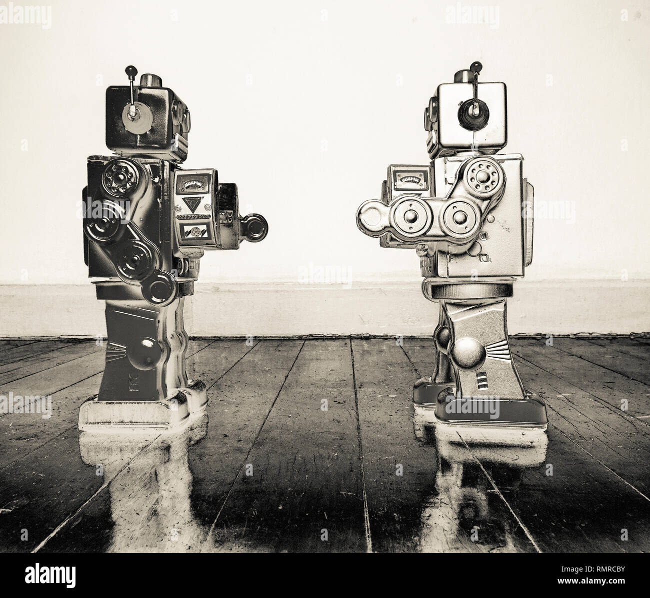 two retro robots face off with ray guns on a wooden floor with ...