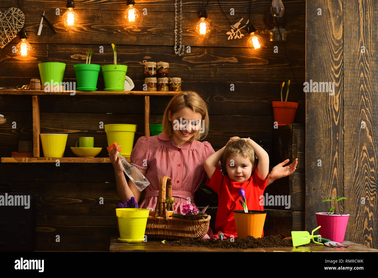 Kid concept. Happy kid potting plants with mother. Kid learn planting ...
