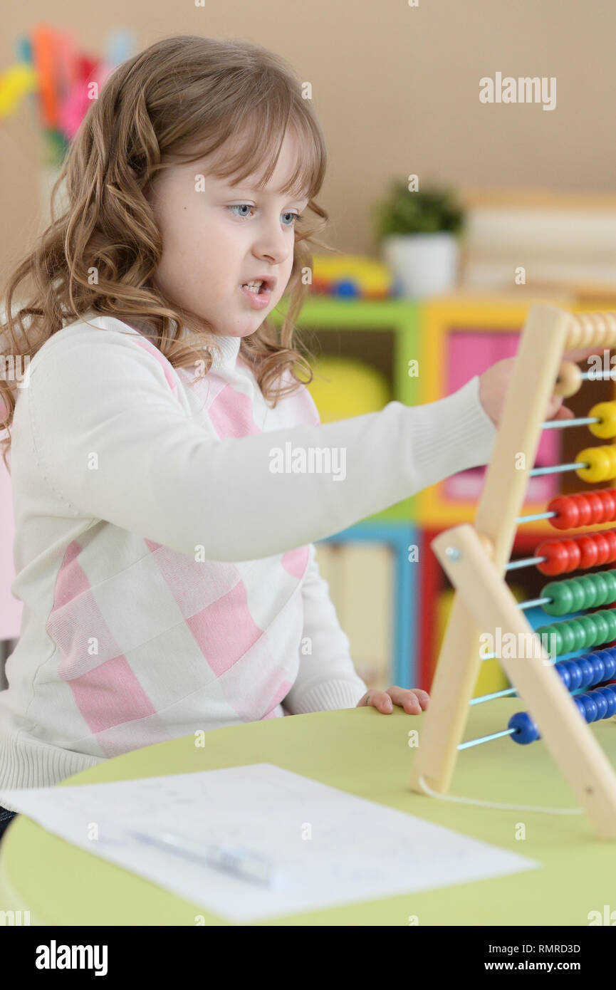 Portrait of little girl counting on abacus Stock Photo - Alamy