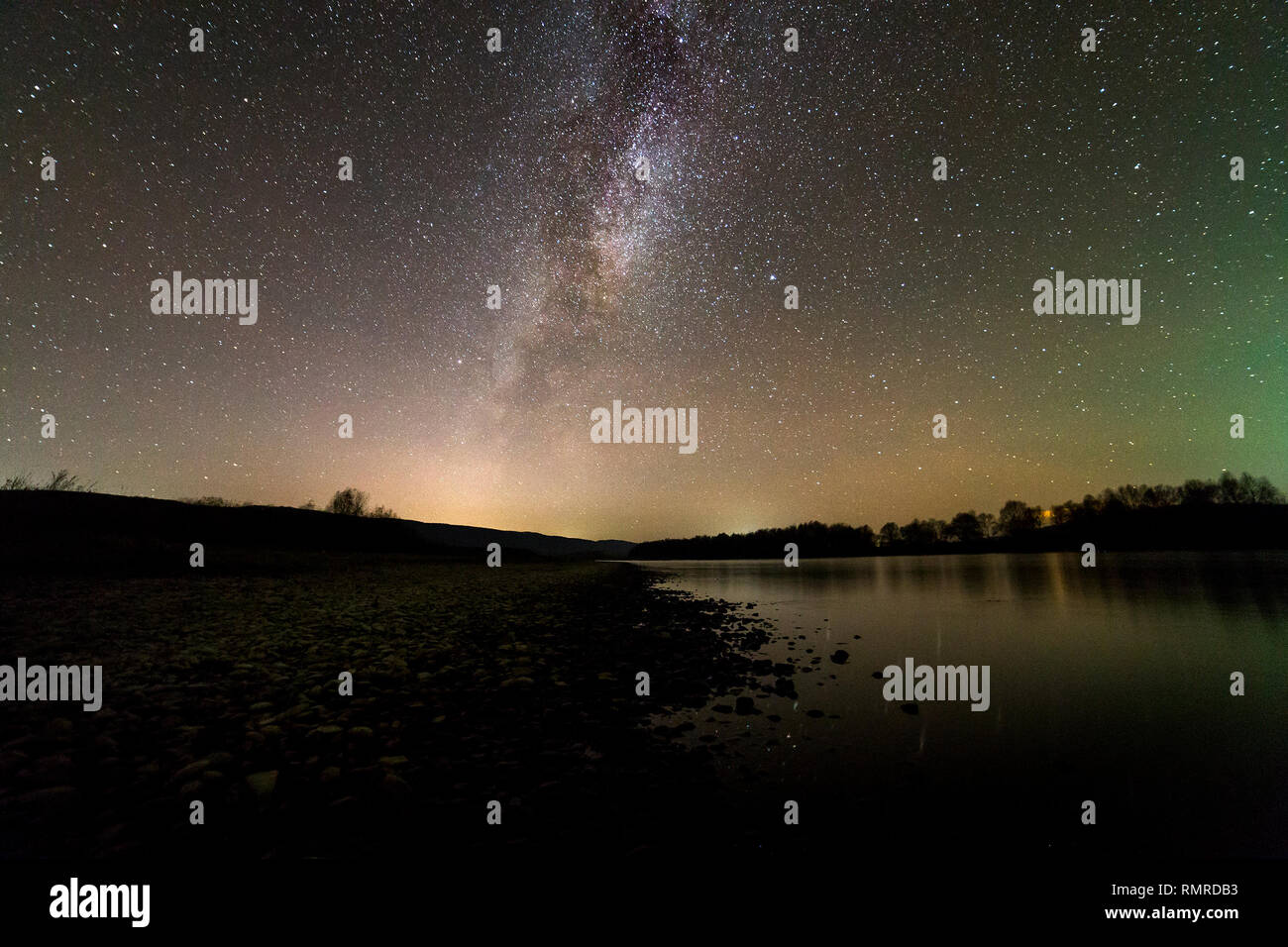 Landscape of pebbles river bank, trees on horizon, bright stars and ...