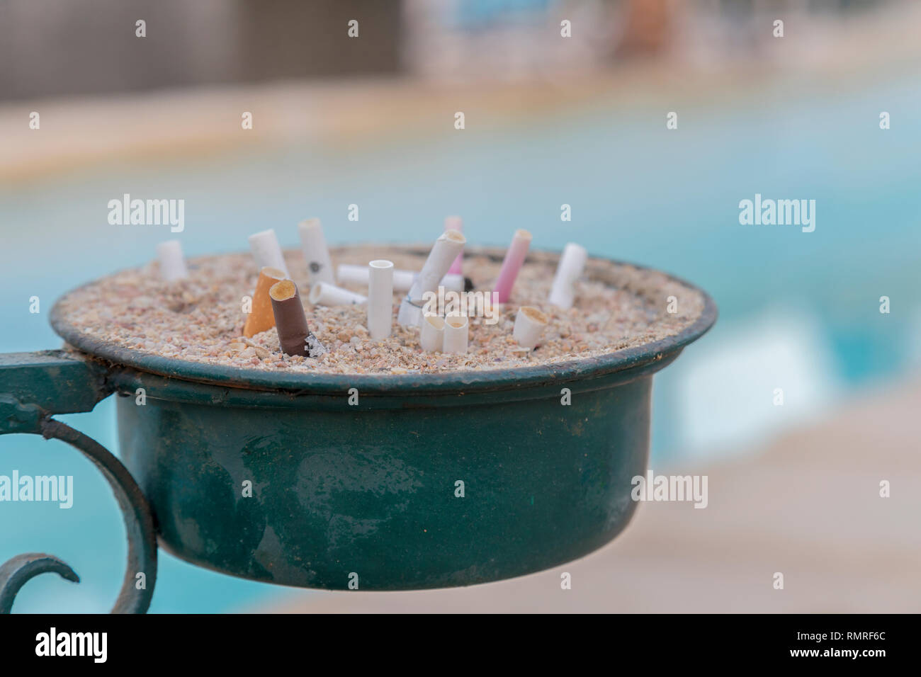 Cigarette butts in the urn. Cigarette disposal urn full of cigarettes ...