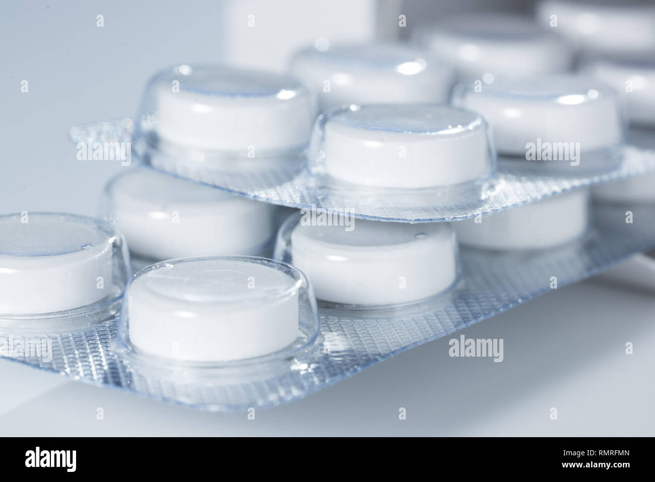 White pills in silver packaging on a white background Stock Photo - Alamy