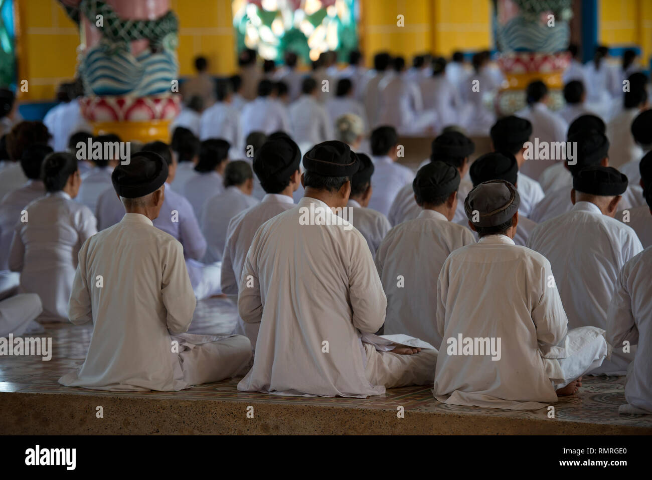 Caodaist disciples, sitting by colorful columns with dragons, Cao Dai ...